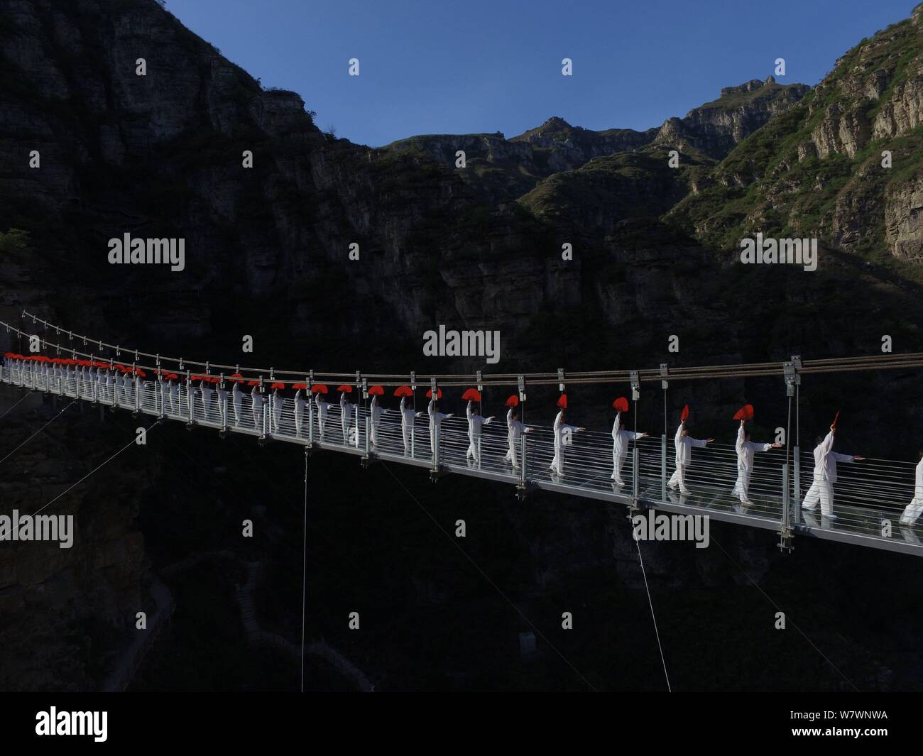 Chinese enthusiasts perform Taichi on a suspended glass bridge at a ...