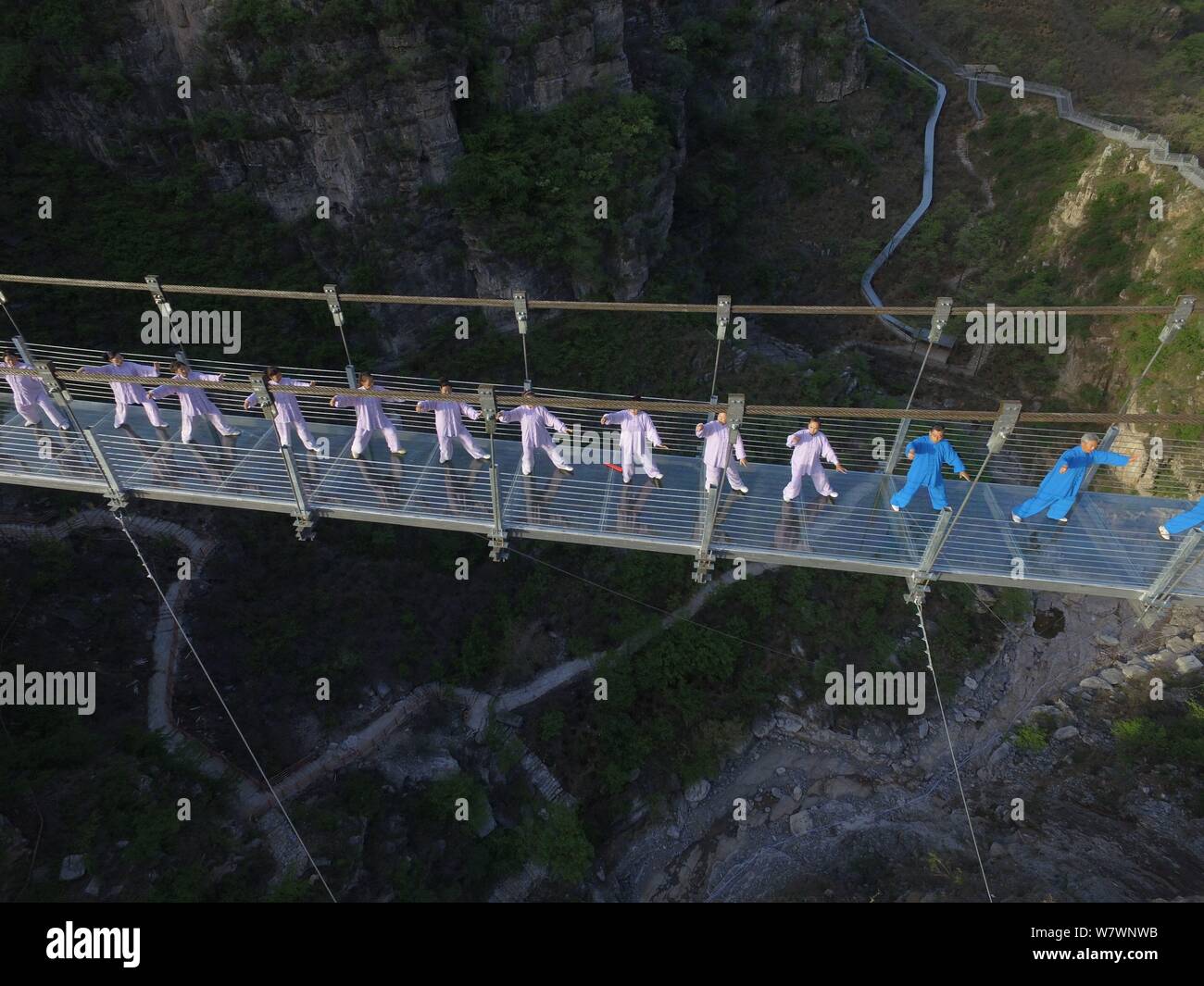 Chinese enthusiasts perform Taichi on a suspended glass bridge at a ...