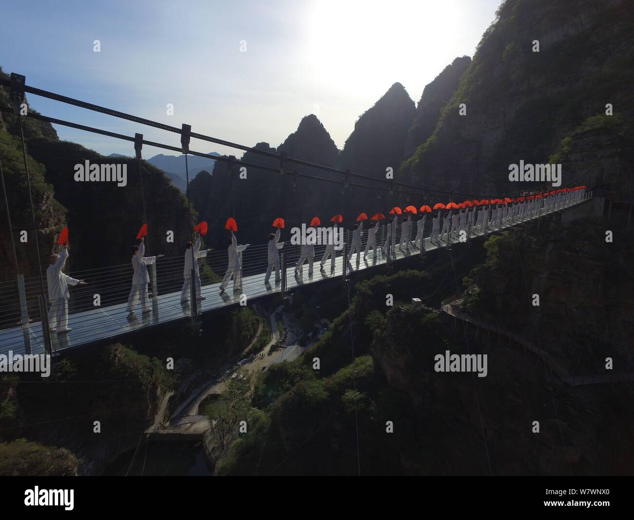 Chinese enthusiasts perform Taichi on a suspended glass bridge at a ...