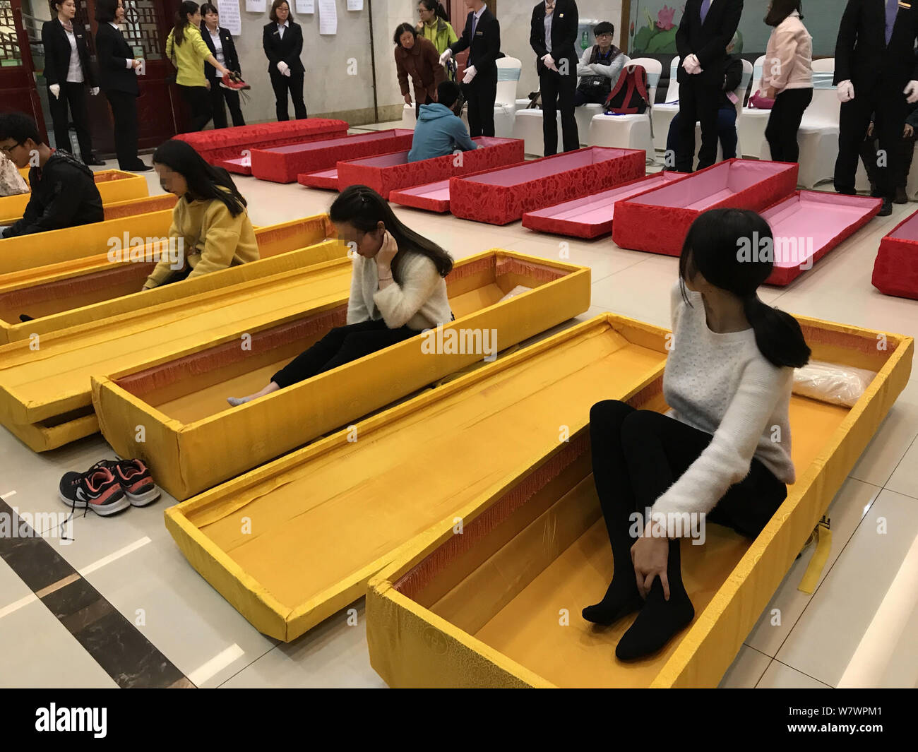 Chinese participants prepare to lie in coffin-like paper boxes in an ...