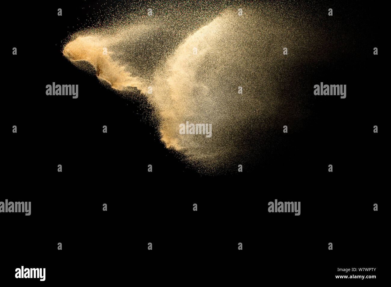 Sand explosion isolated on black background. Freeze motion of sandy ...