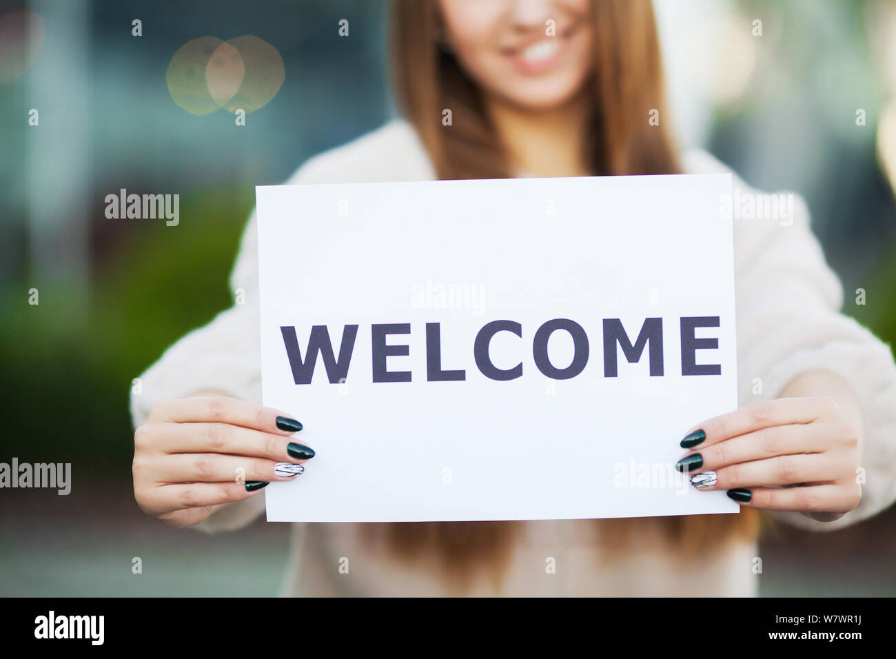 Women business with the poster with welcome message Stock Photo - Alamy