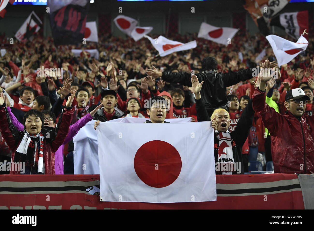 Football fans wave Japanese national flags and shout slogans to show ...