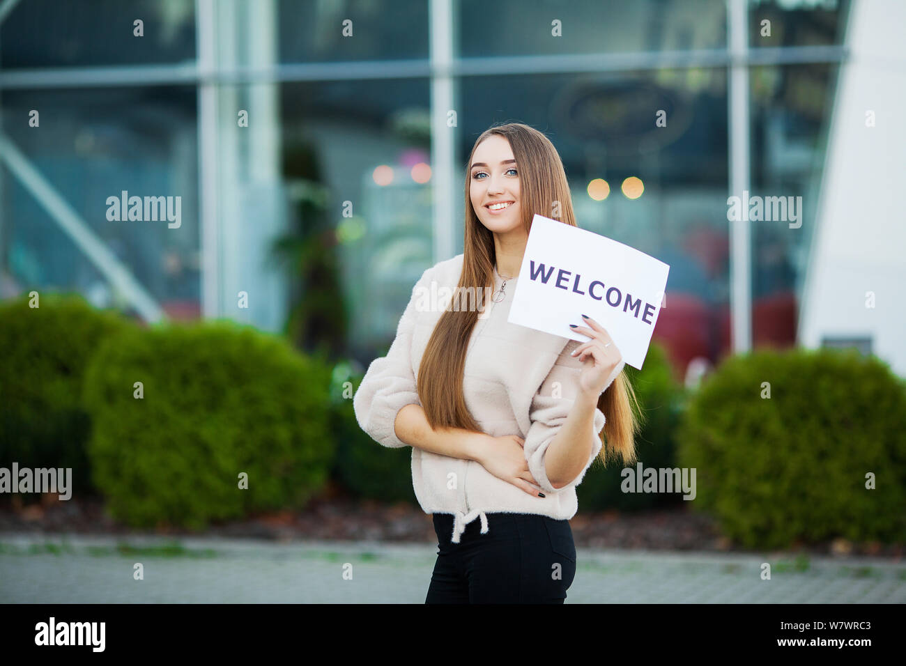 Women business with the poster with welcome message Stock Photo - Alamy