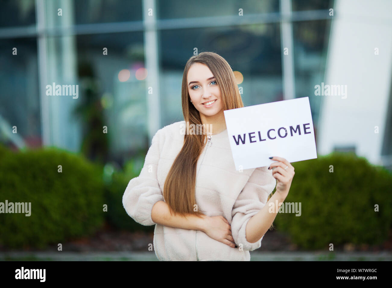 Women business with the poster with welcome message Stock Photo - Alamy