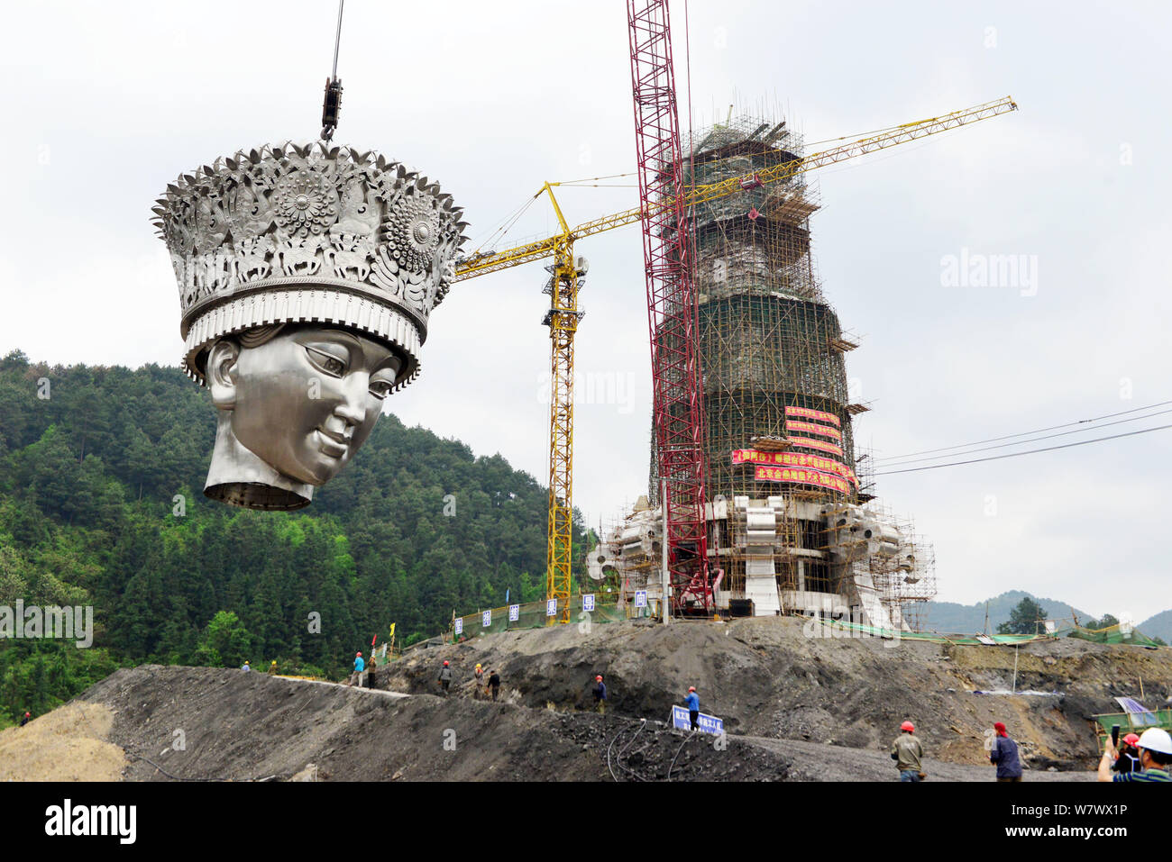 A crane lifts the head of a giant statue of Yang'asha, the Goddess of ...