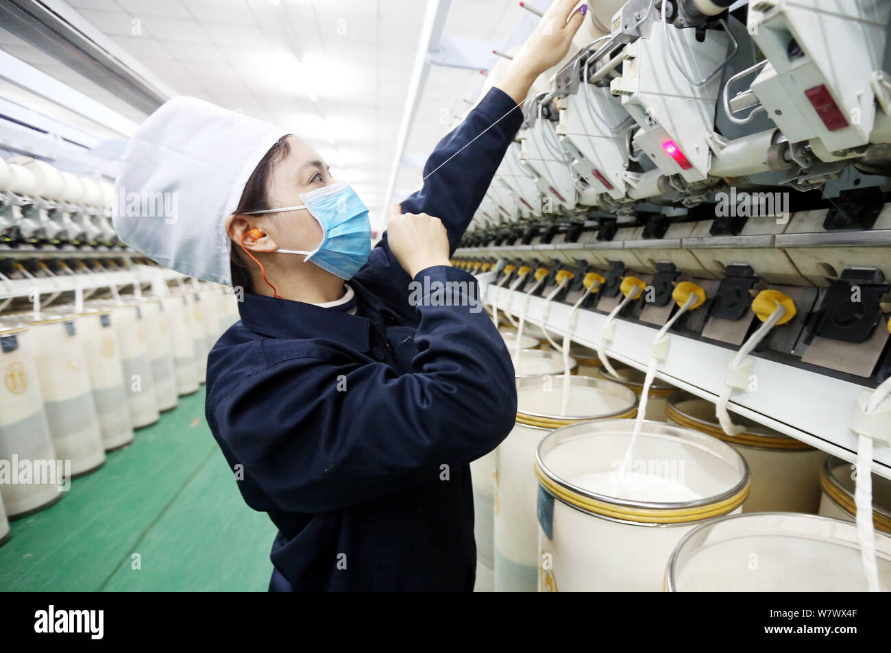 --FILE--A Chinese worker handles production of yarn at a textile ...