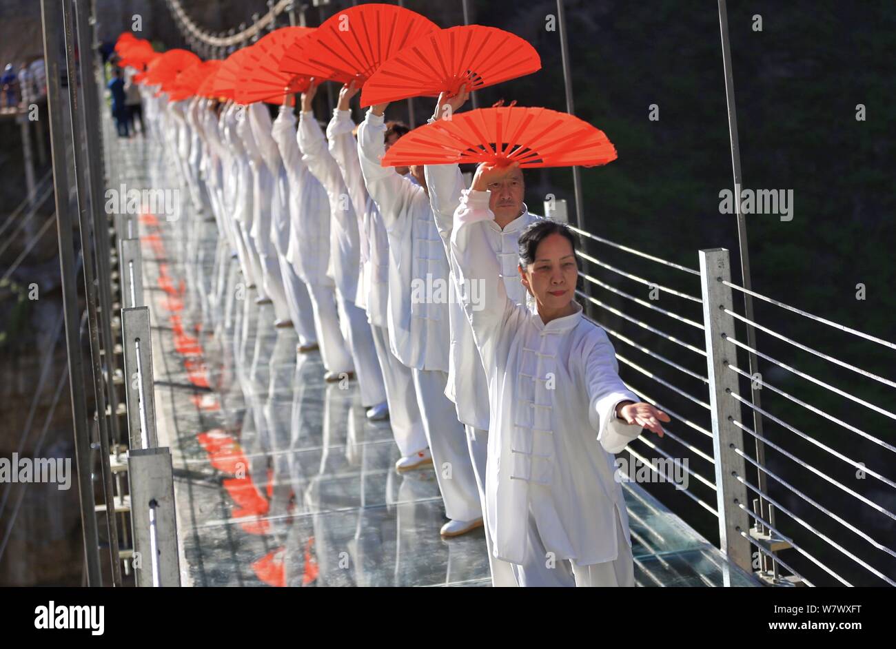 Chinese enthusiasts perform Taichi on a suspended glass bridge at a ...