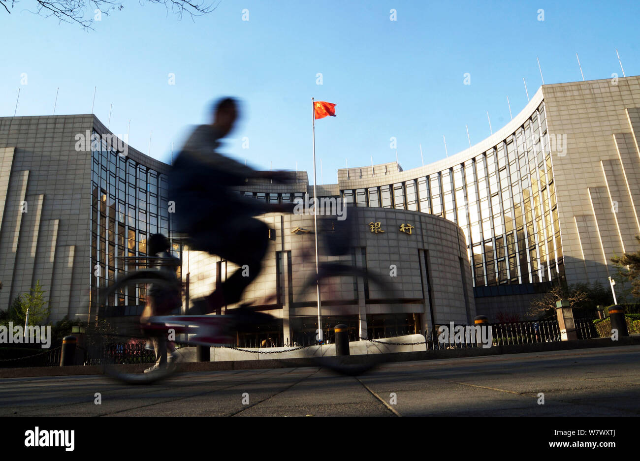 --FILE--A cyclist rides past the headquarters and head office of the ...