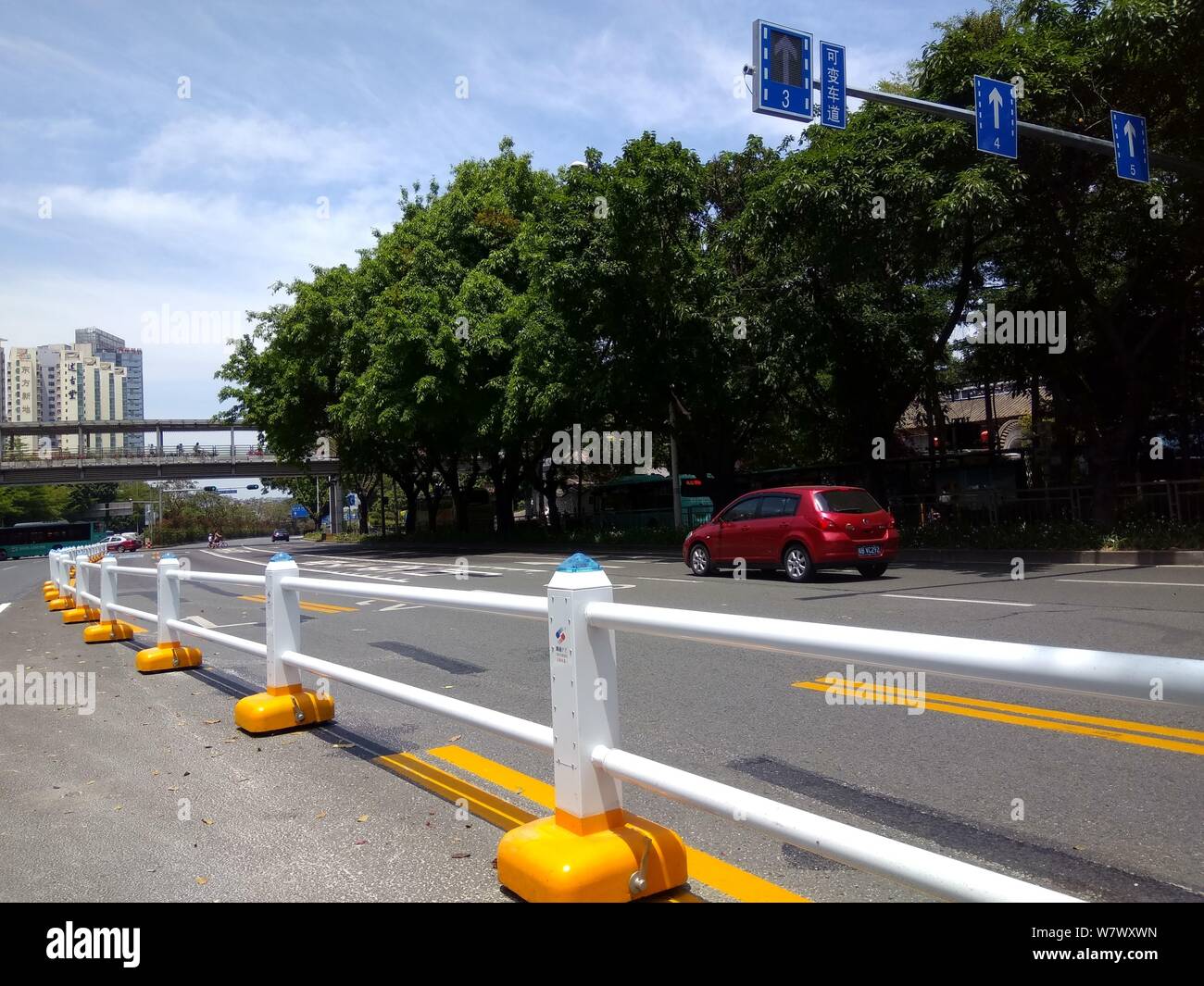 Vehicles drive on a reversible lane with a guardrail controlled by ...