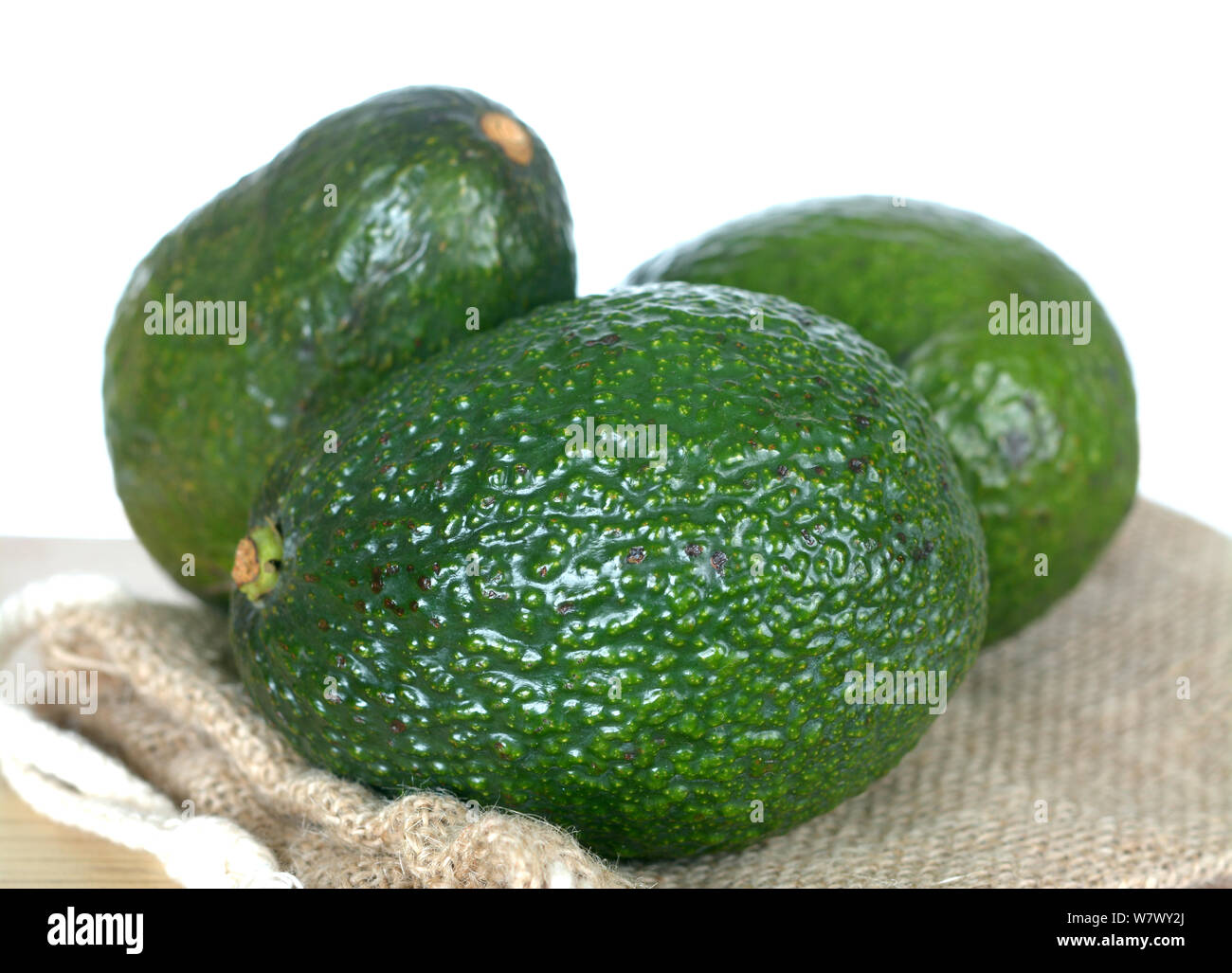three avocado fruit on the table on white background Stock Photo - Alamy