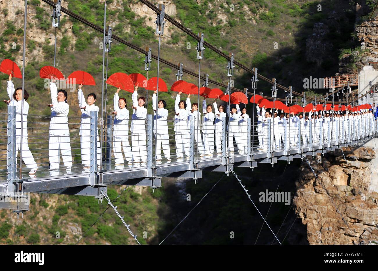Chinese enthusiasts perform Taichi on a suspended glass bridge at a ...