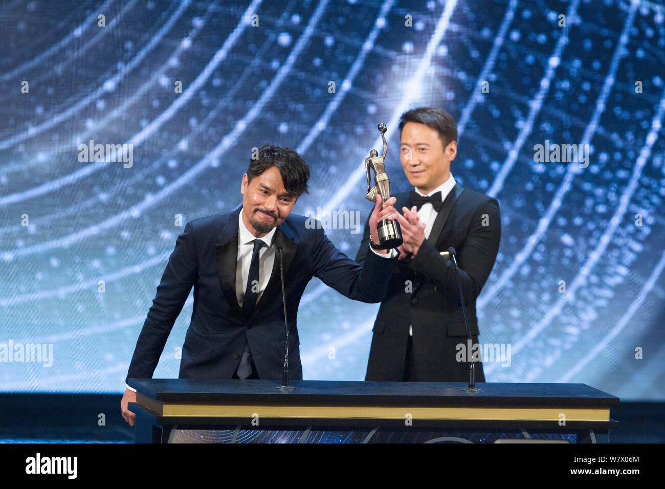 Hong Kong actor Gordon Lam, left, holds up his trophy after winning the ...