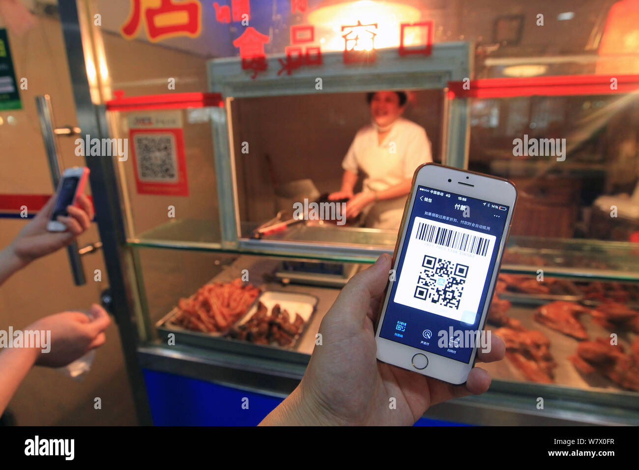 --FILE--A Chinese customer scans a QR code via mobile payment service ...