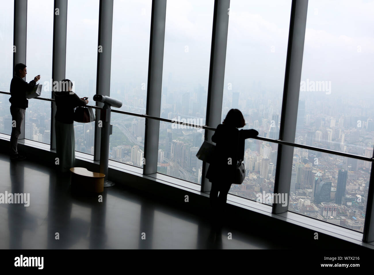 Visitors look at the cityscape of Shanghai in the sightseeing ...