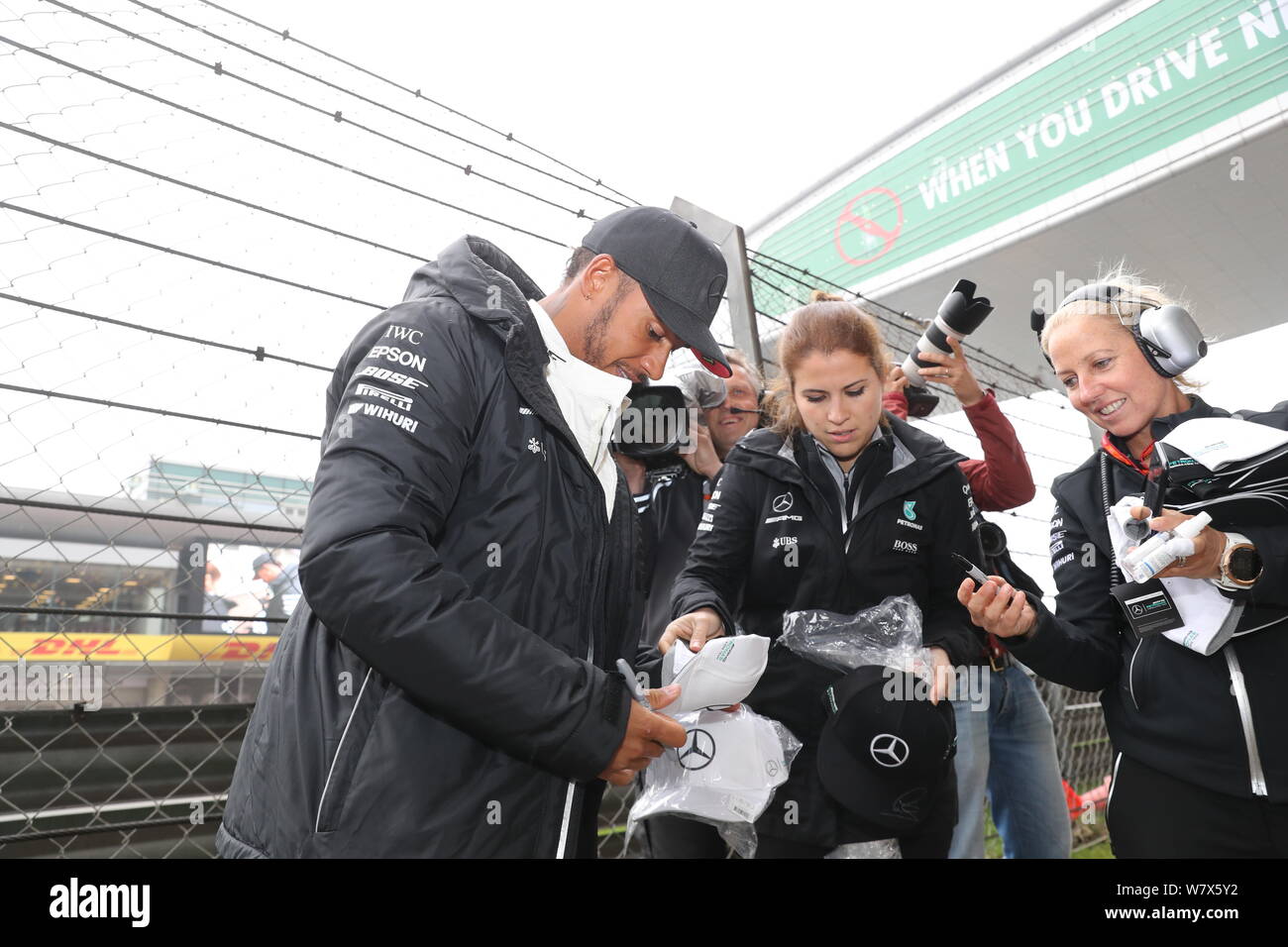 British F1 driver Lewis Hamilton of Mercedes signs autographs for fans ...