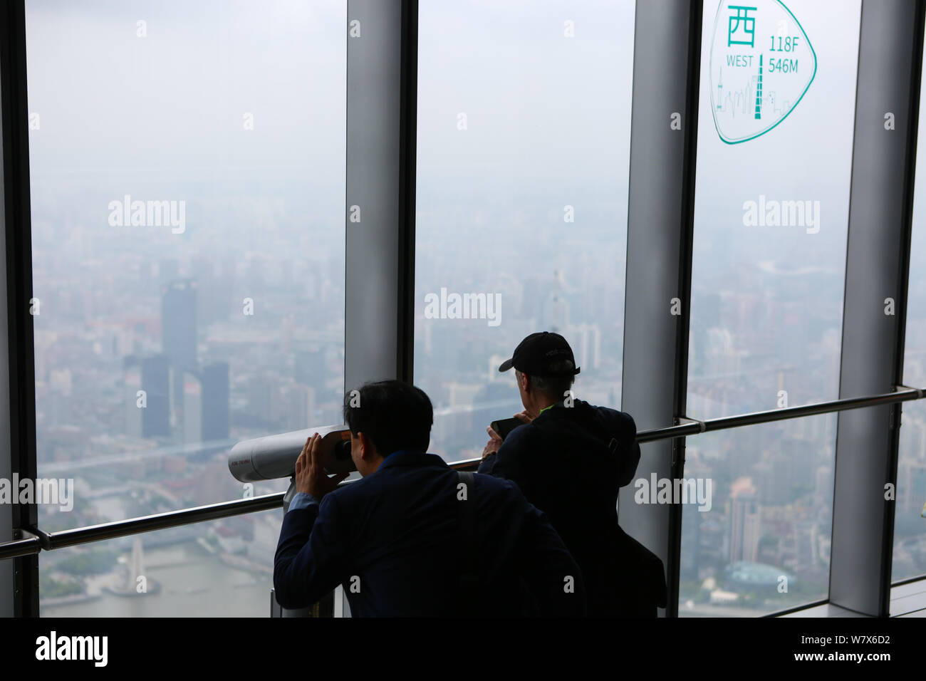 Visitors look at the cityscape of Shanghai in the sightseeing ...