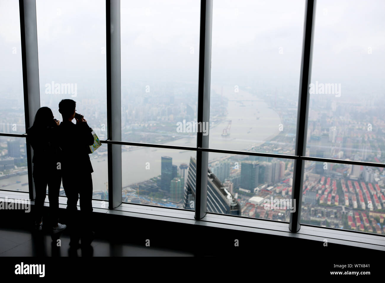 Visitors look at the cityscape of Shanghai in the sightseeing ...