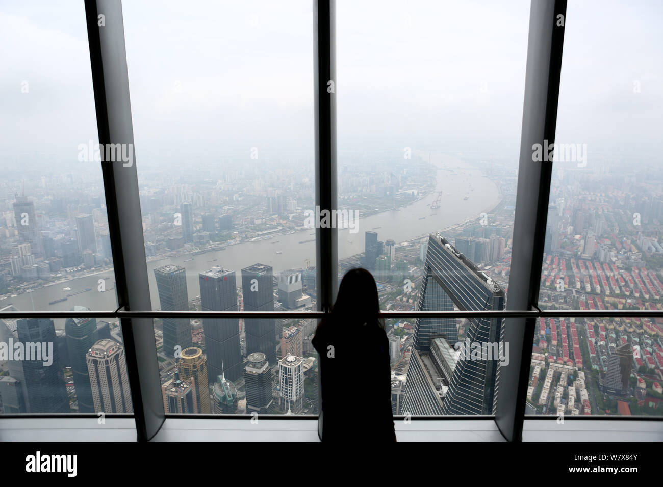 A visitor looks at the cityscape of Shanghai in the sightseeing ...