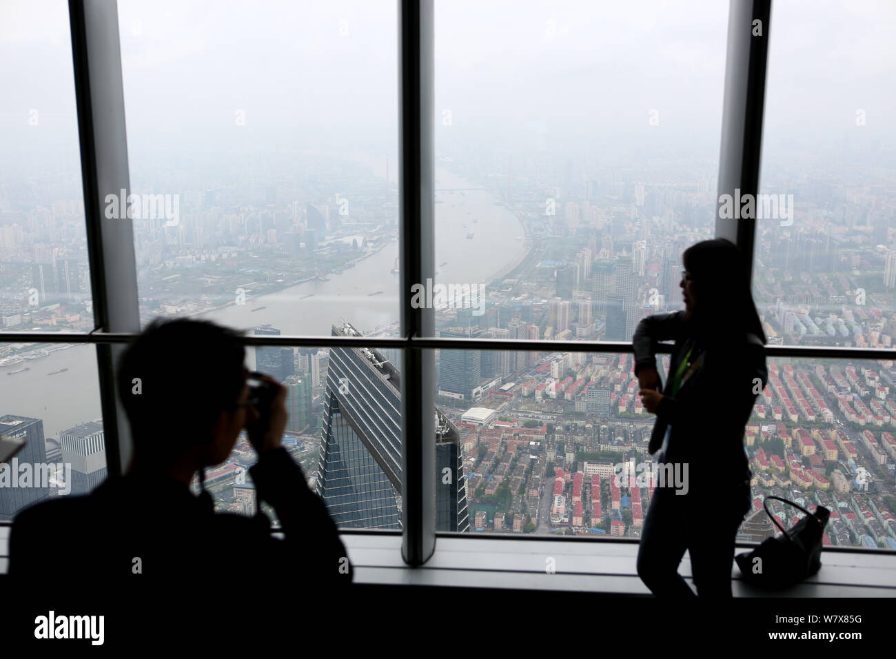 Visitors take photos of the cityscape of Shanghai in the sightseeing ...