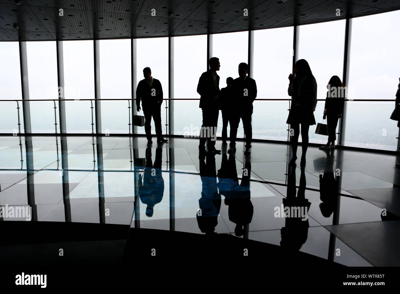 Visitors look at the cityscape of Shanghai in the sightseeing ...
