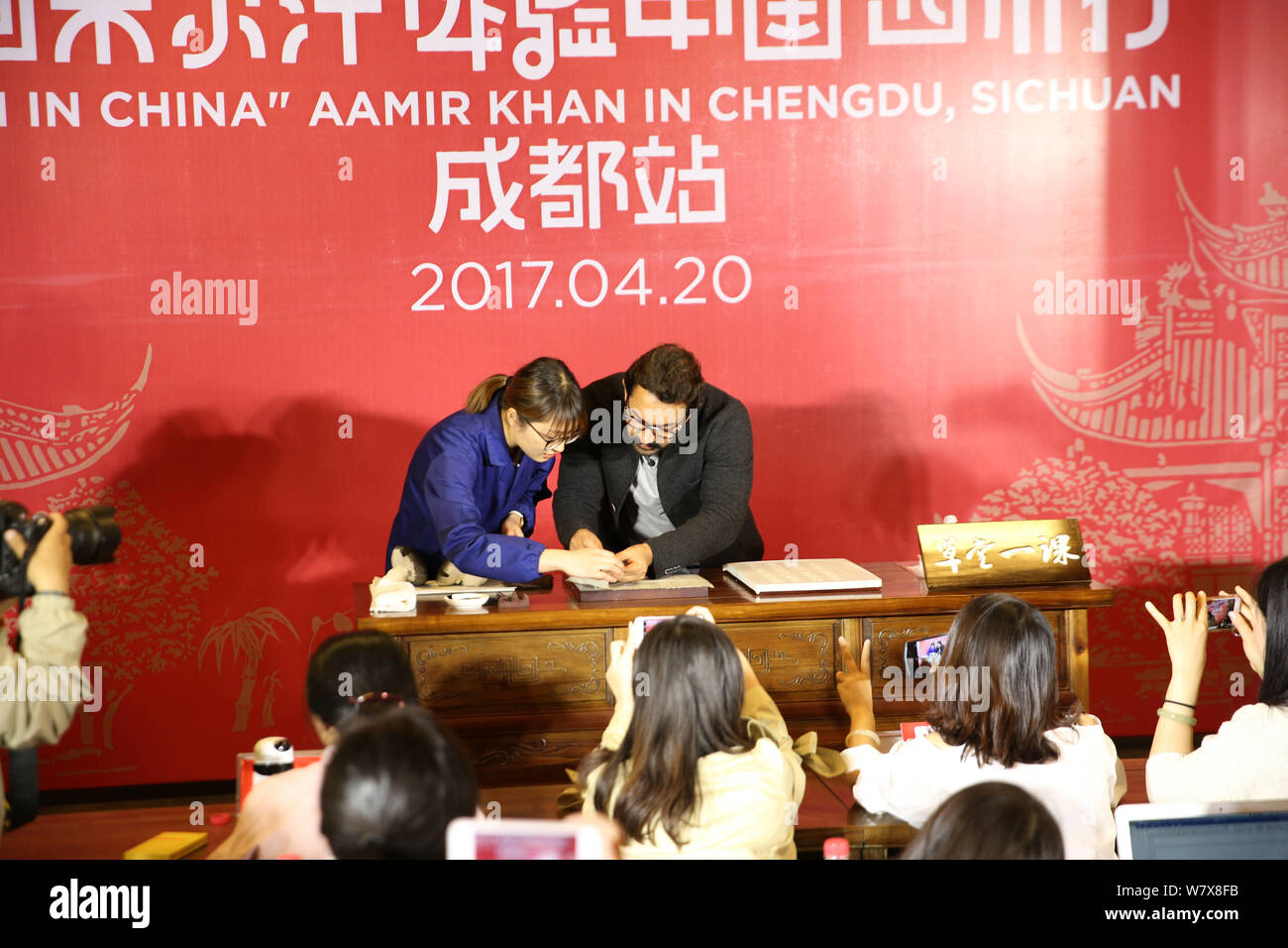 Indian actor Aamir Khan, right, rubs a poem by ancient Chinese poet Du ...