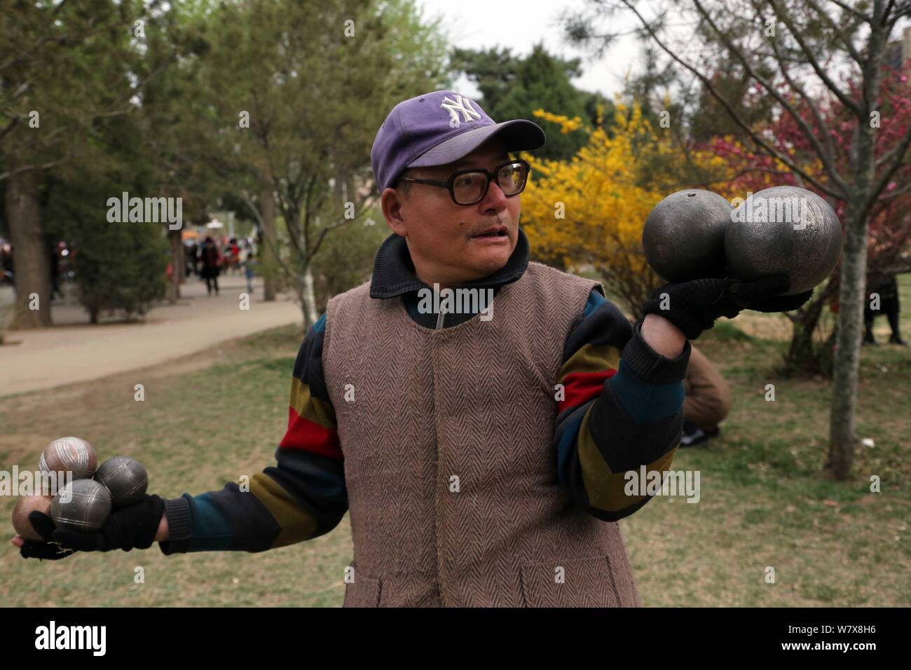 61-year-old Chinese man Piao Yingmin plays iron balls at a park in ...