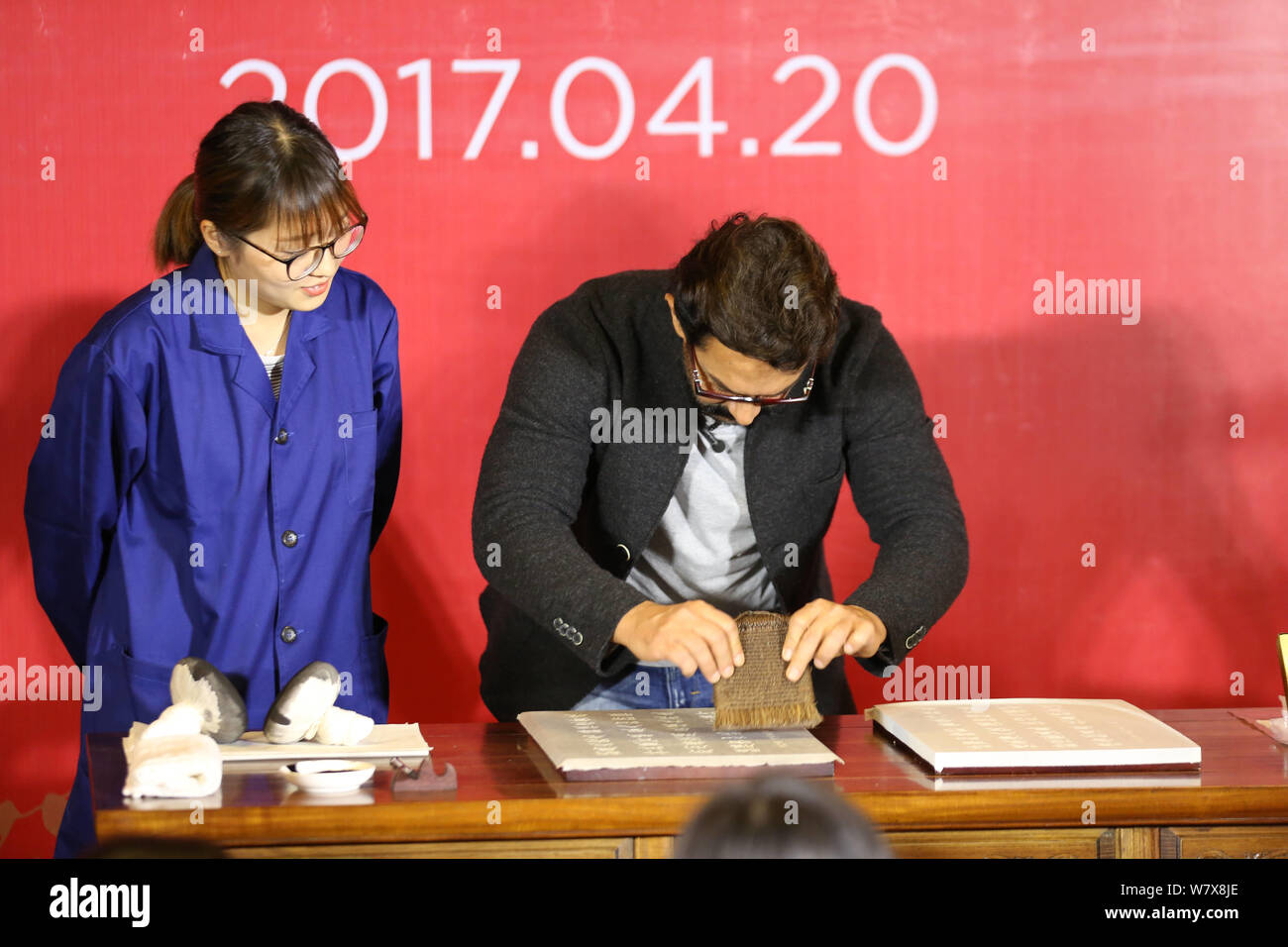 Indian actor Aamir Khan, right, rubs a poem by ancient Chinese poet Du ...