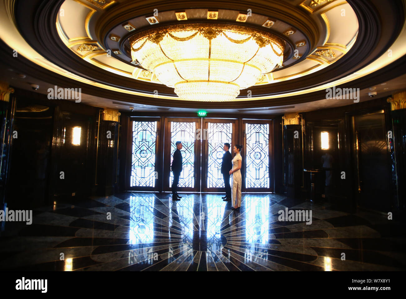 A Chinese waitress dressed in cheongsam, also known as qipao in Chinese ...