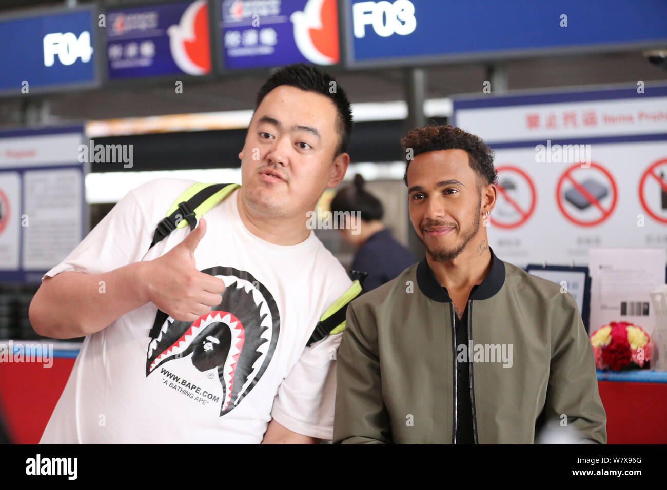 British F1 driver Lewis Hamilton of Mercedes, right, poses with a fan ...