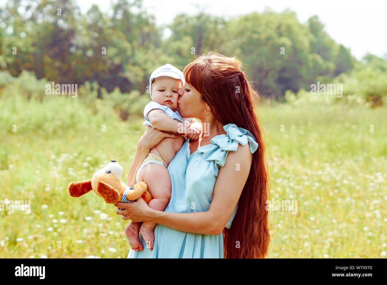 A young mother raised her baby in her arms Stock Photo - Alamy
