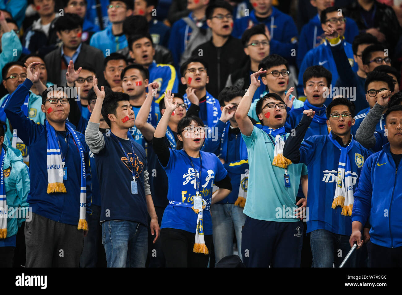 Football fans shout slogans to show support for China's Jiangsu Suning ...