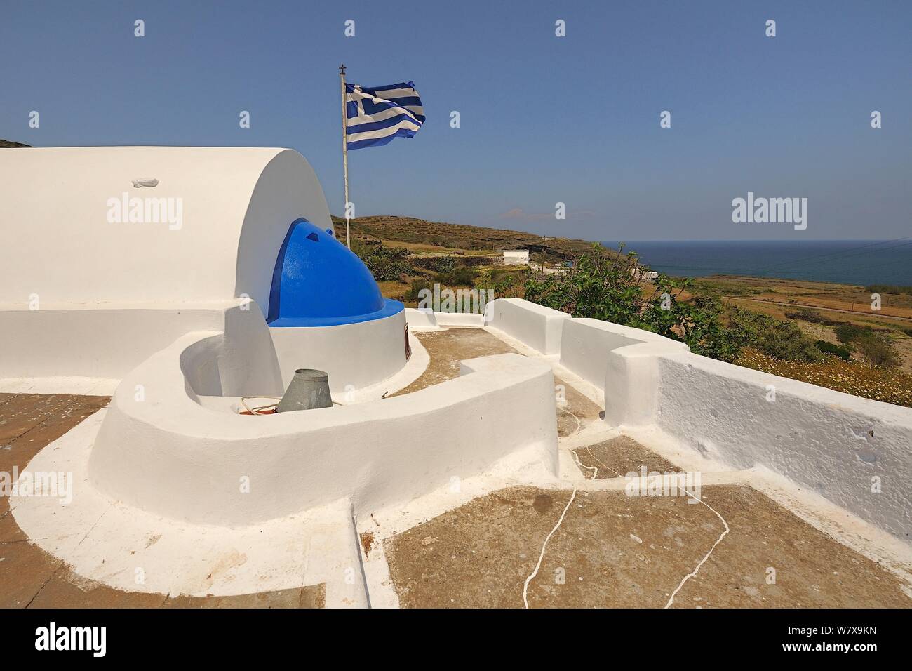 Traditional Cycladic building with Greek national flag, Oia, Santorini ...