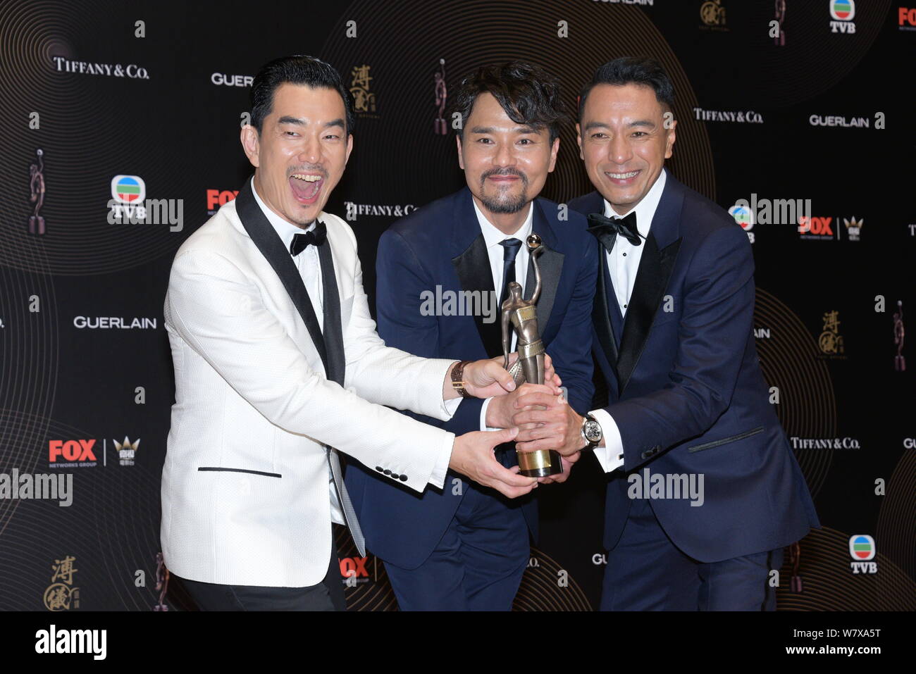 Hong Kong actor Gordon Lam, center, poses with his trophy after winning ...