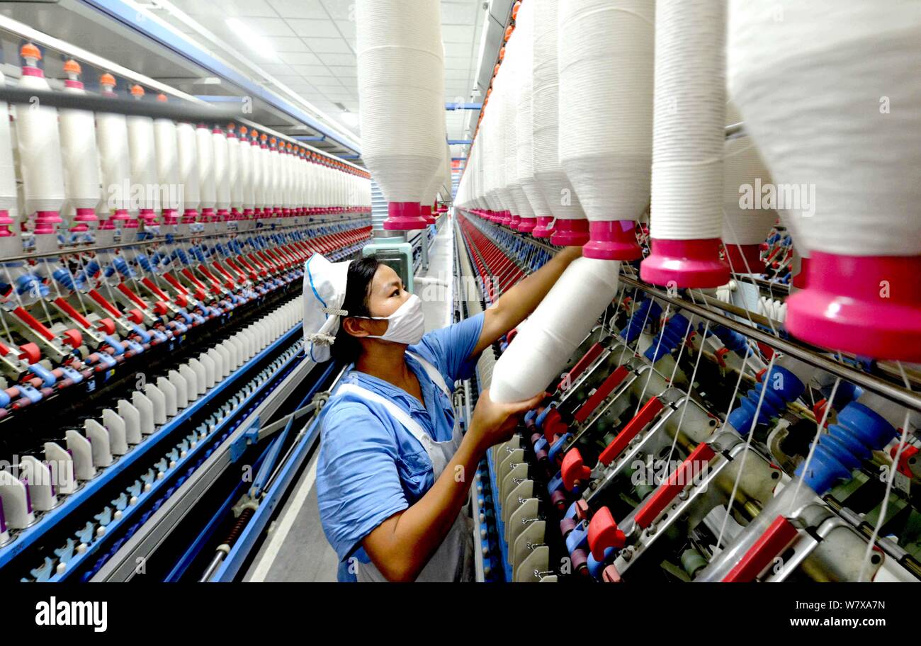 --FILE--A Chinese worker handles production of yarn at a textile ...