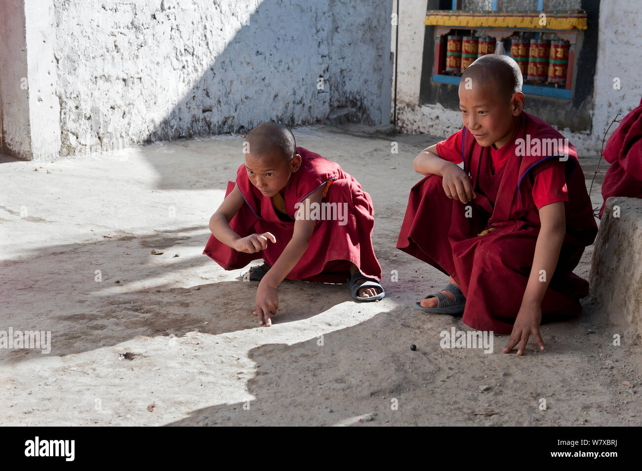 Young monks playing marbles during a break at the Torgya festival ...