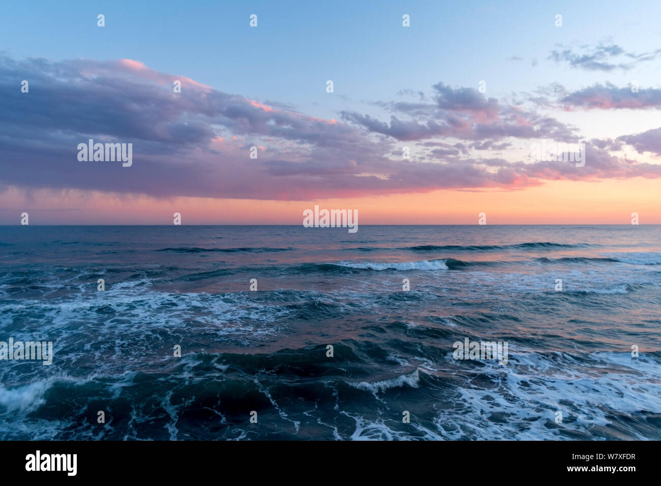 Dramatic colorful clouds at sunset hovering over the sea Stock Photo ...
