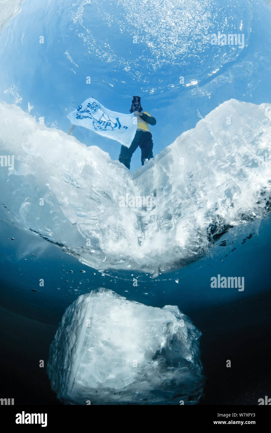 Man visible on surface of the ice through dive hole. Lake Baikal ...