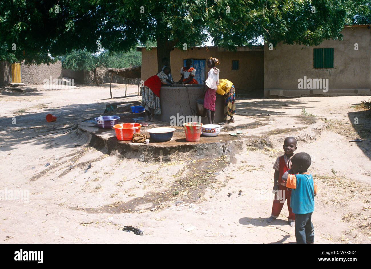 Women and children collecting water at village well, rural Chad, 2002 ...