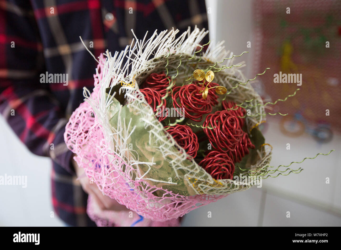 Chinese craftsman Li Yanfeng shows a bunch of wire woven roses made by ...