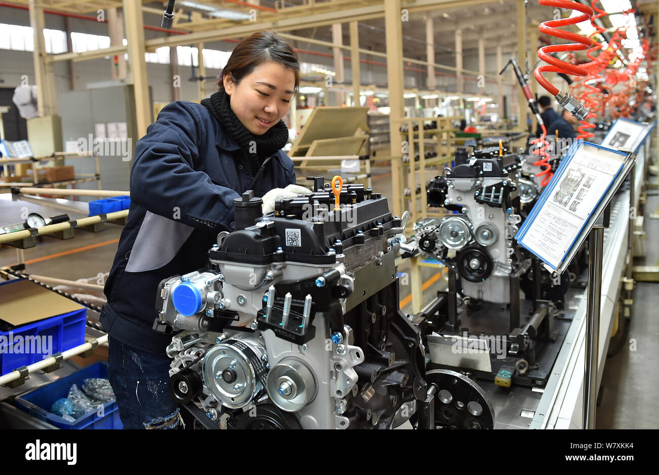 --FILE--A Chinese worker assembles an engine on the assembly line at an ...