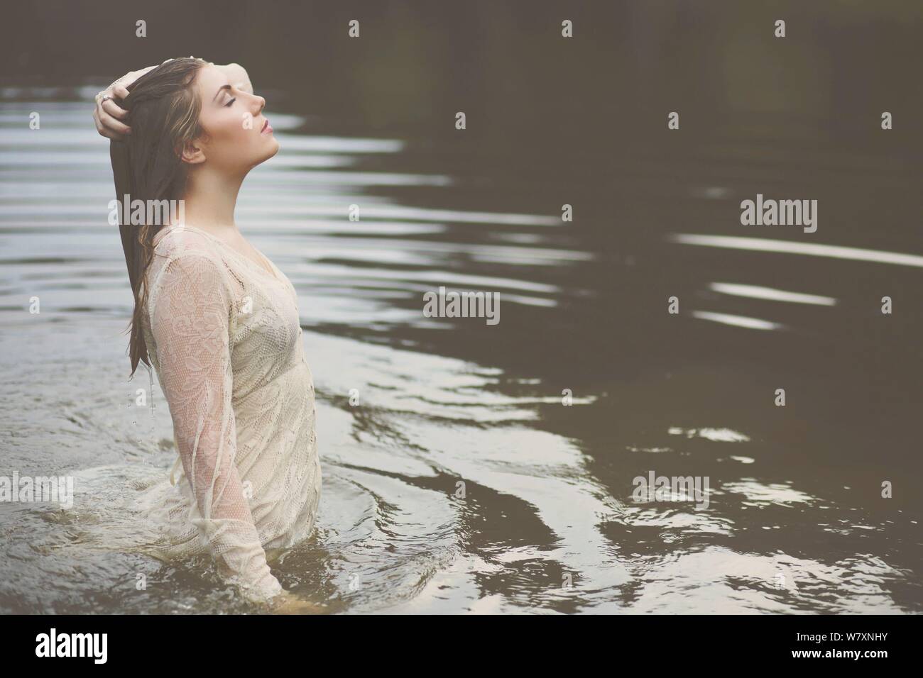 side view of woman standing in water Stock Photo - Alamy