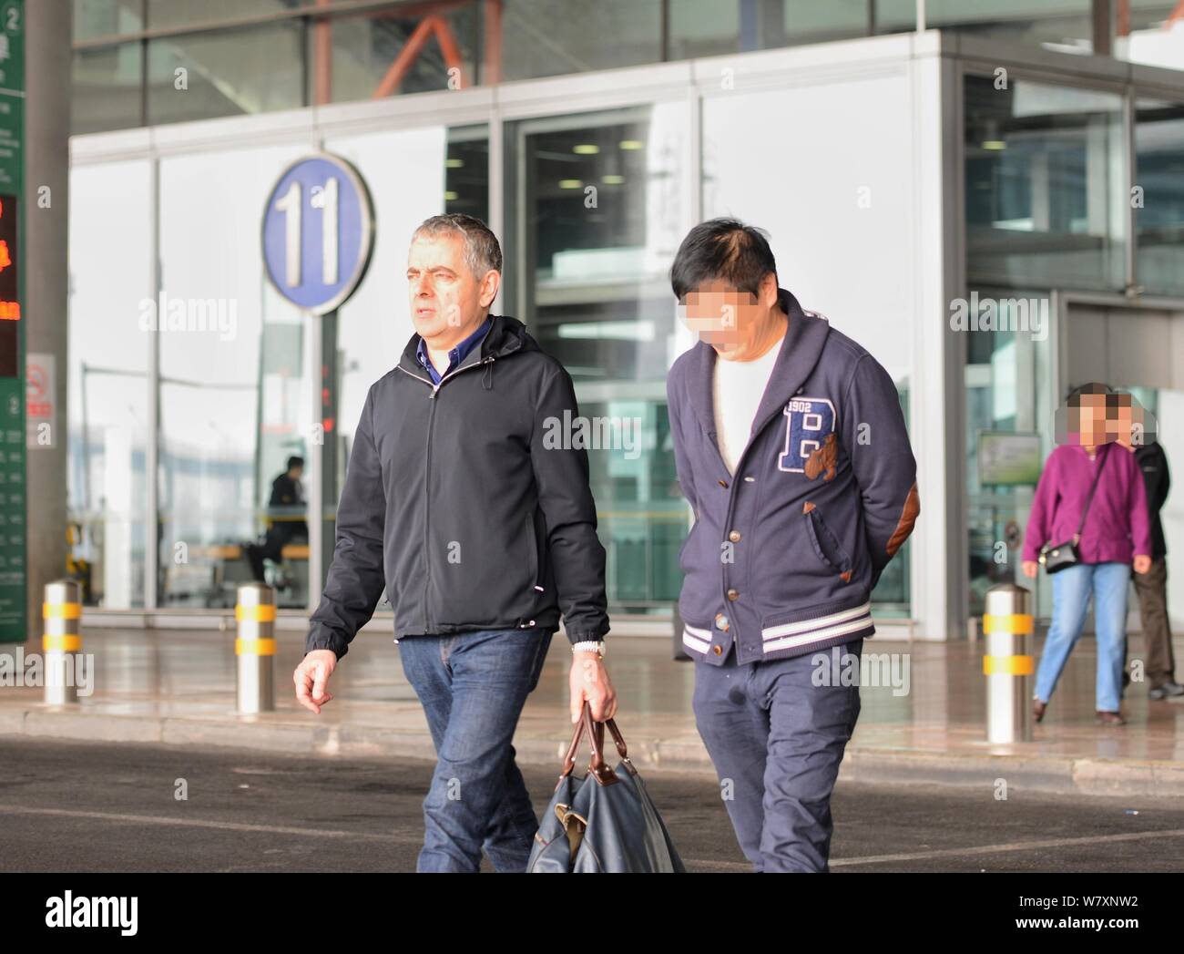 English actor Rowan Atkinson, left, is pictured after arriving at the ...