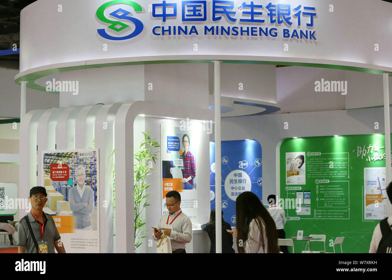 --FILE--Chinese employees are seen at the stand of China Minsheng Bank ...