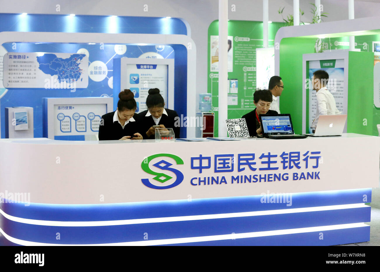 --FILE--Chinese employees are seen at the stand of China Minsheng Bank ...