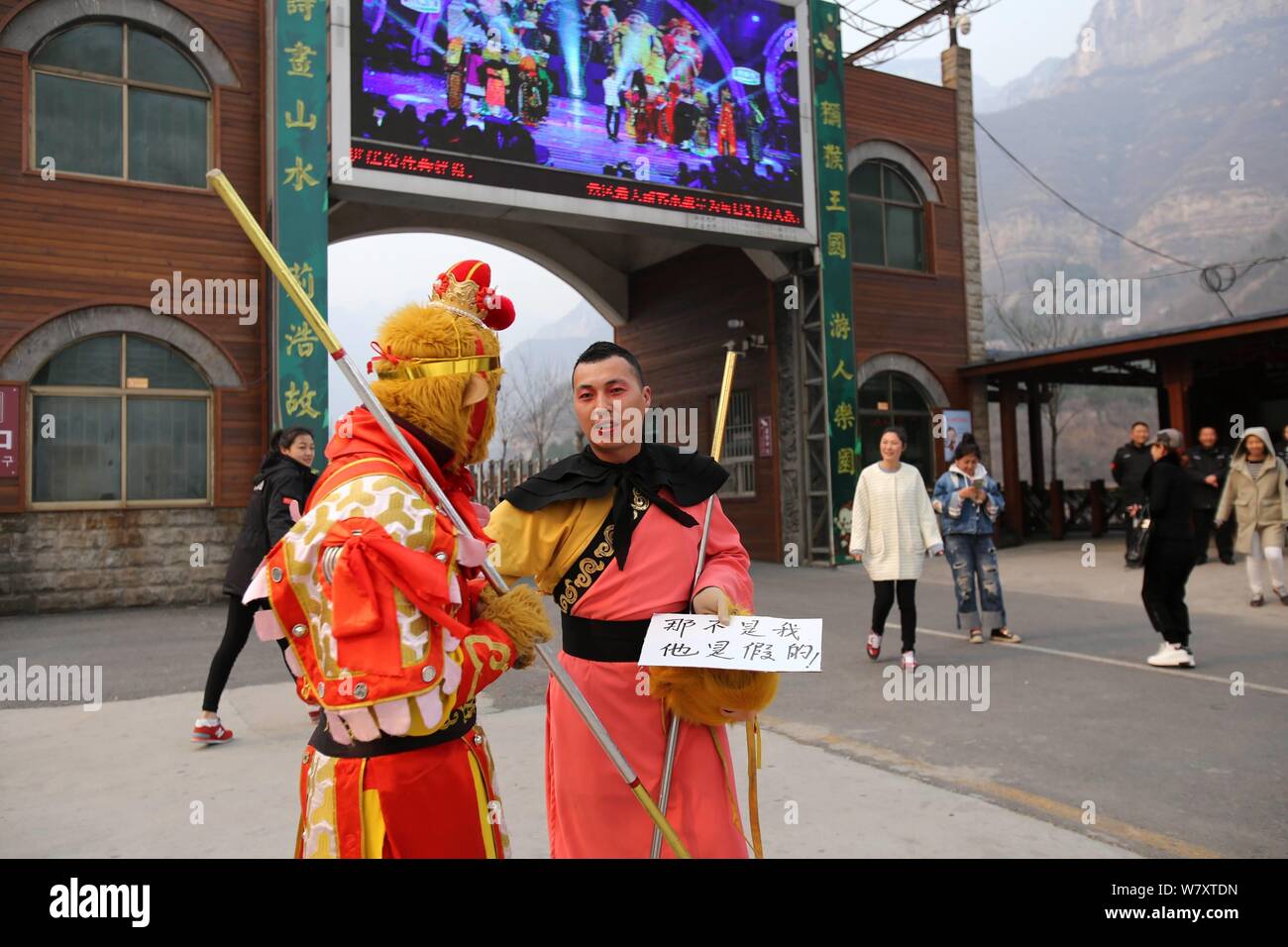 The "Monkey King" bus driver, right, holding a board writing "That's ...