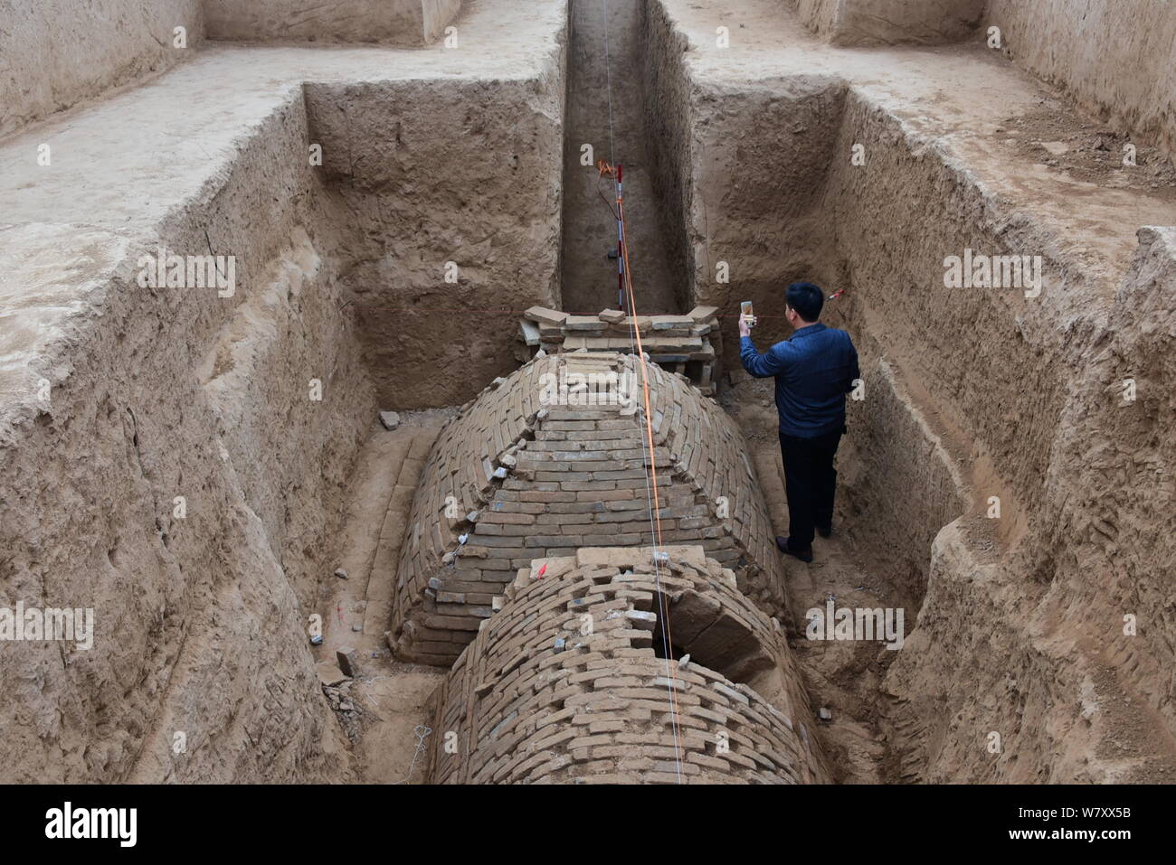 A Chinese archaeologist investigates a tomb in the shape of a pyramid ...