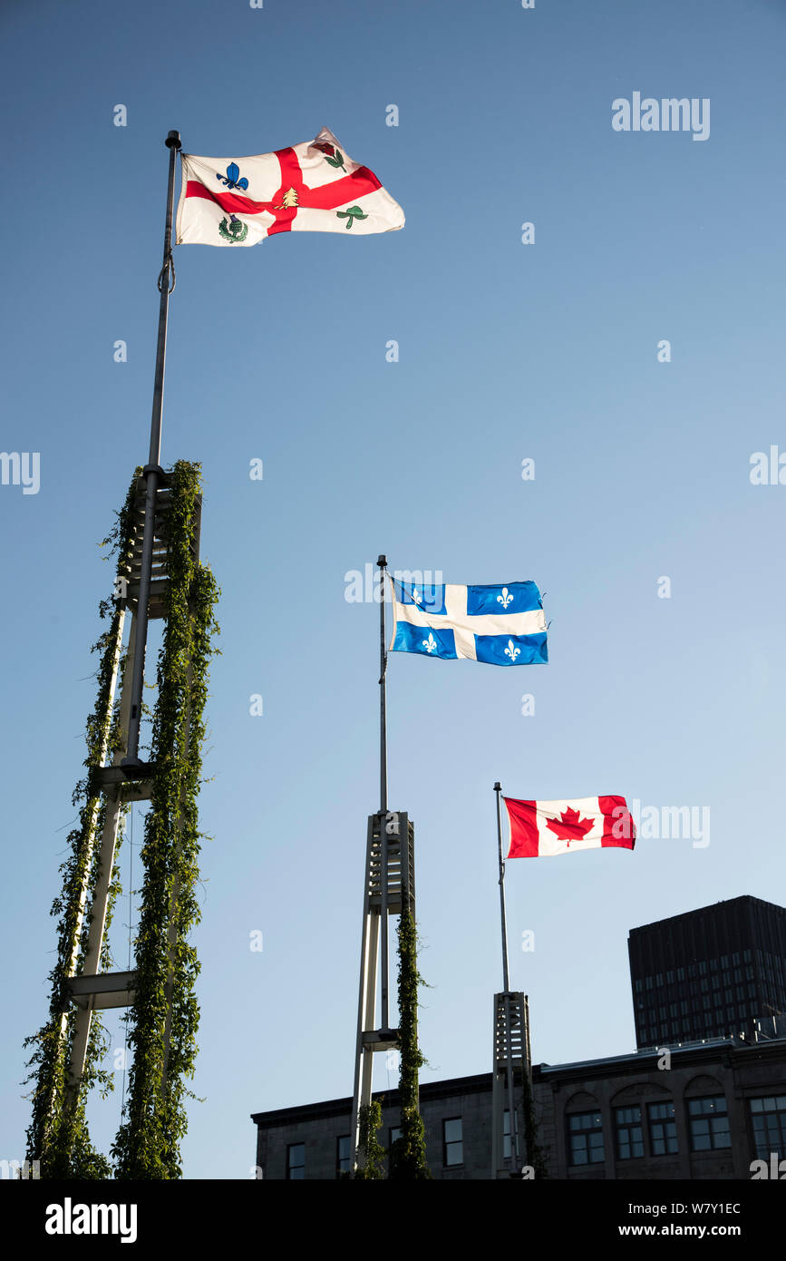 Flags of Montreal, Quebec and Canada against the blue sky Stock Photo ...