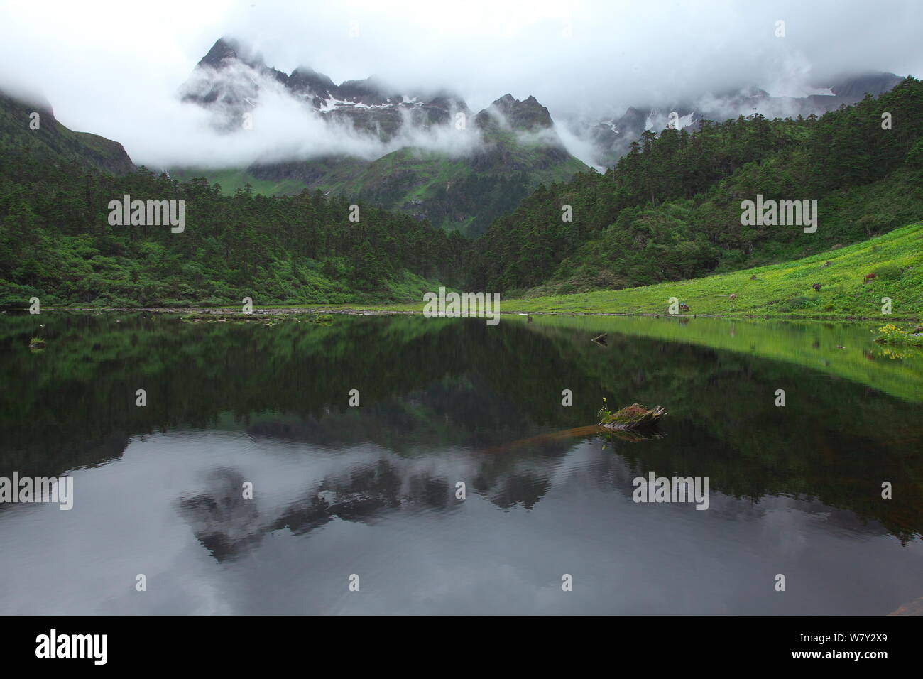 Still lake with mountains shrouded in mist, Kawakarpo Mountain, Meri ...