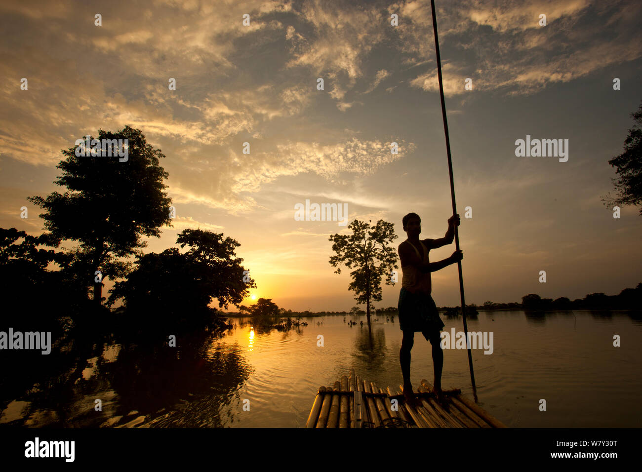Man using a raft to travel through the floods. Kaziranga National Park ...